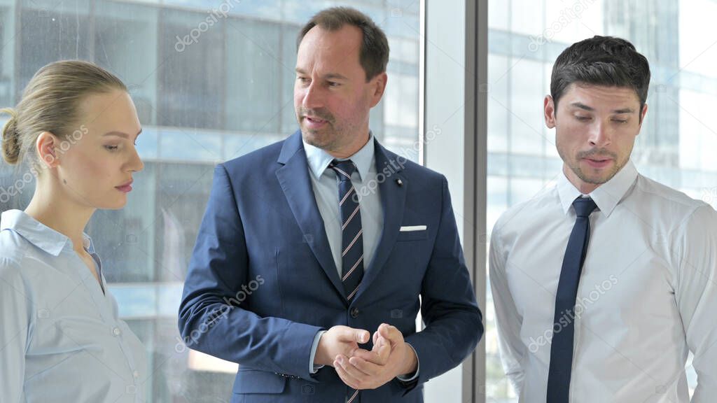 Gerente de mediana edad explicando cosas a sus asistentes en la sala de ...