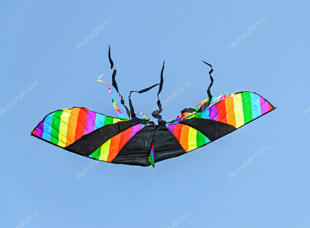 Cometa de color volando en el cielo azul, alas de cerca 2024