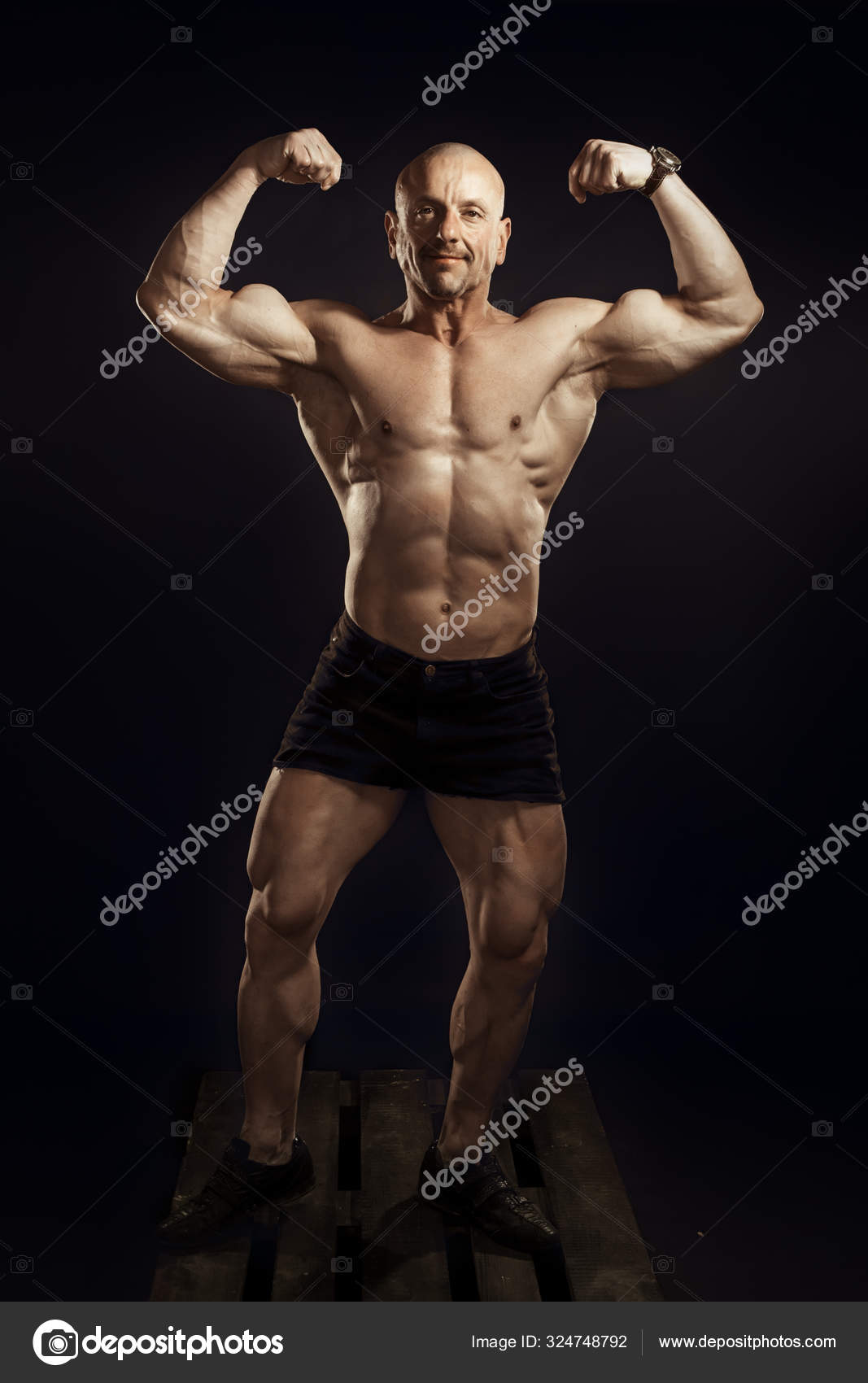 Bodybuilder shows front double biceps in studio Stock Photo by ©Bossa ...