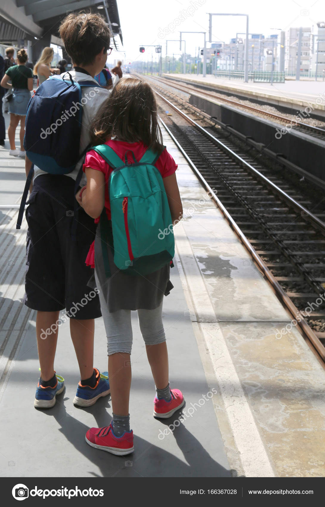 Brother and sister with backpacks waiting ata station — Stock Photo ...