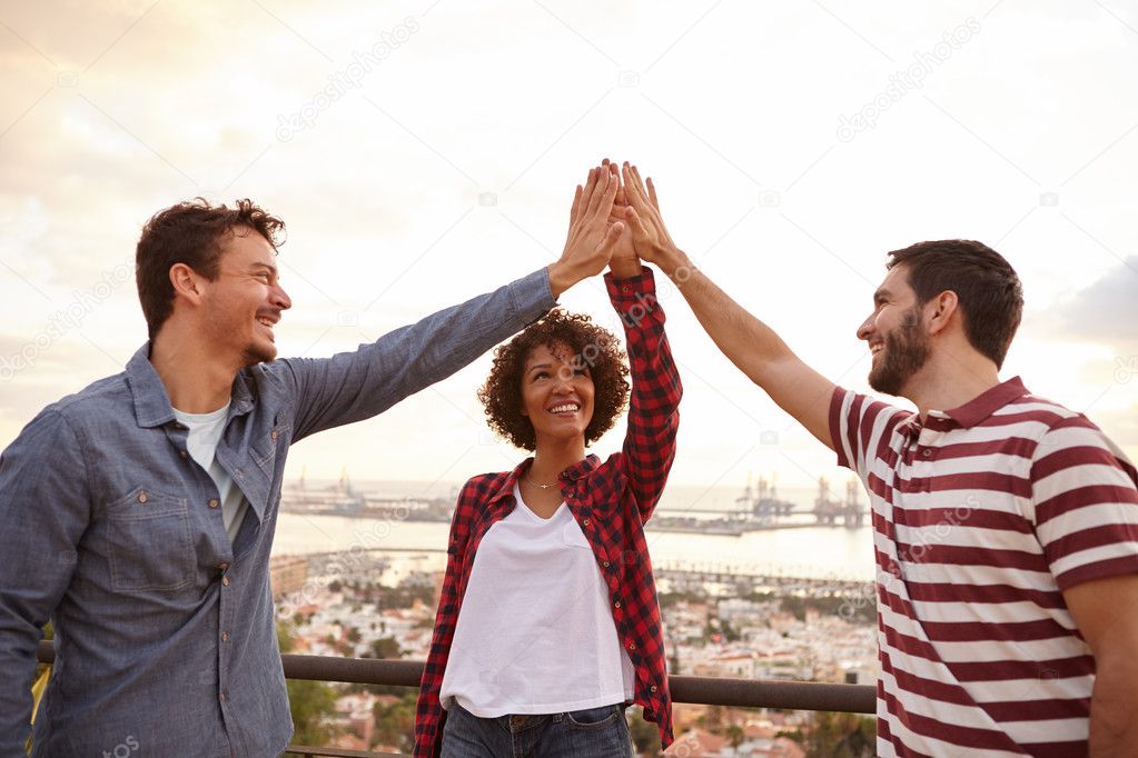 Three smiling friends doing high five — Stock Photo © pablocalvog ...