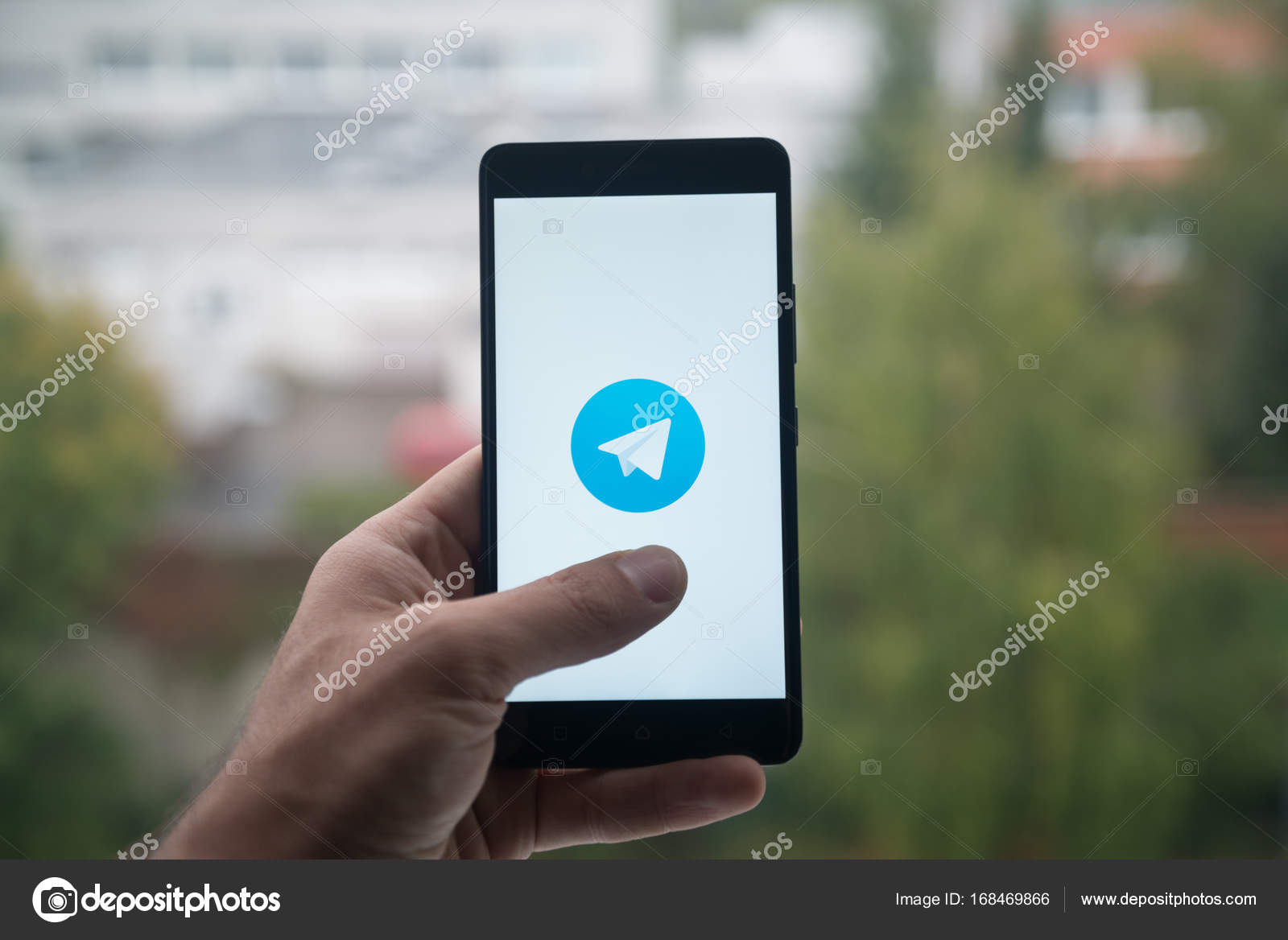 Man holding smartphone with Telegram logo with the finger on the screen ...