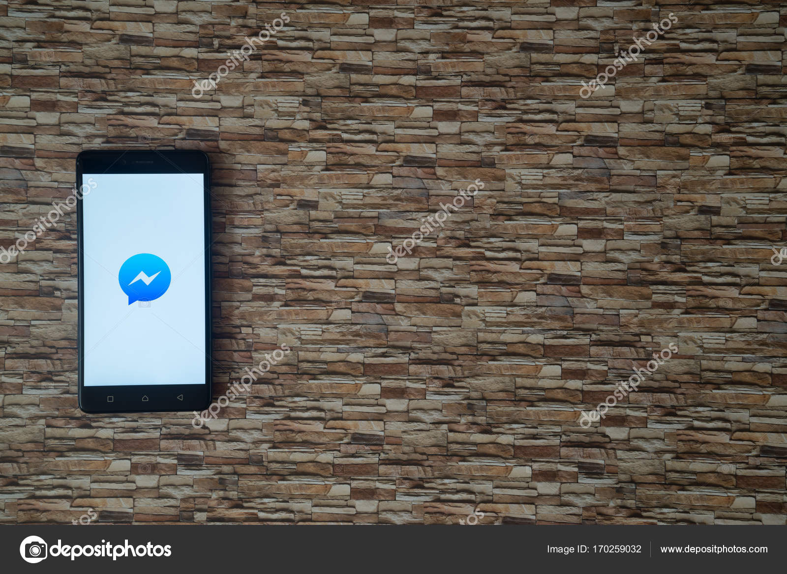 Facebook messenger logo on smartphone screen on stone facing background ...