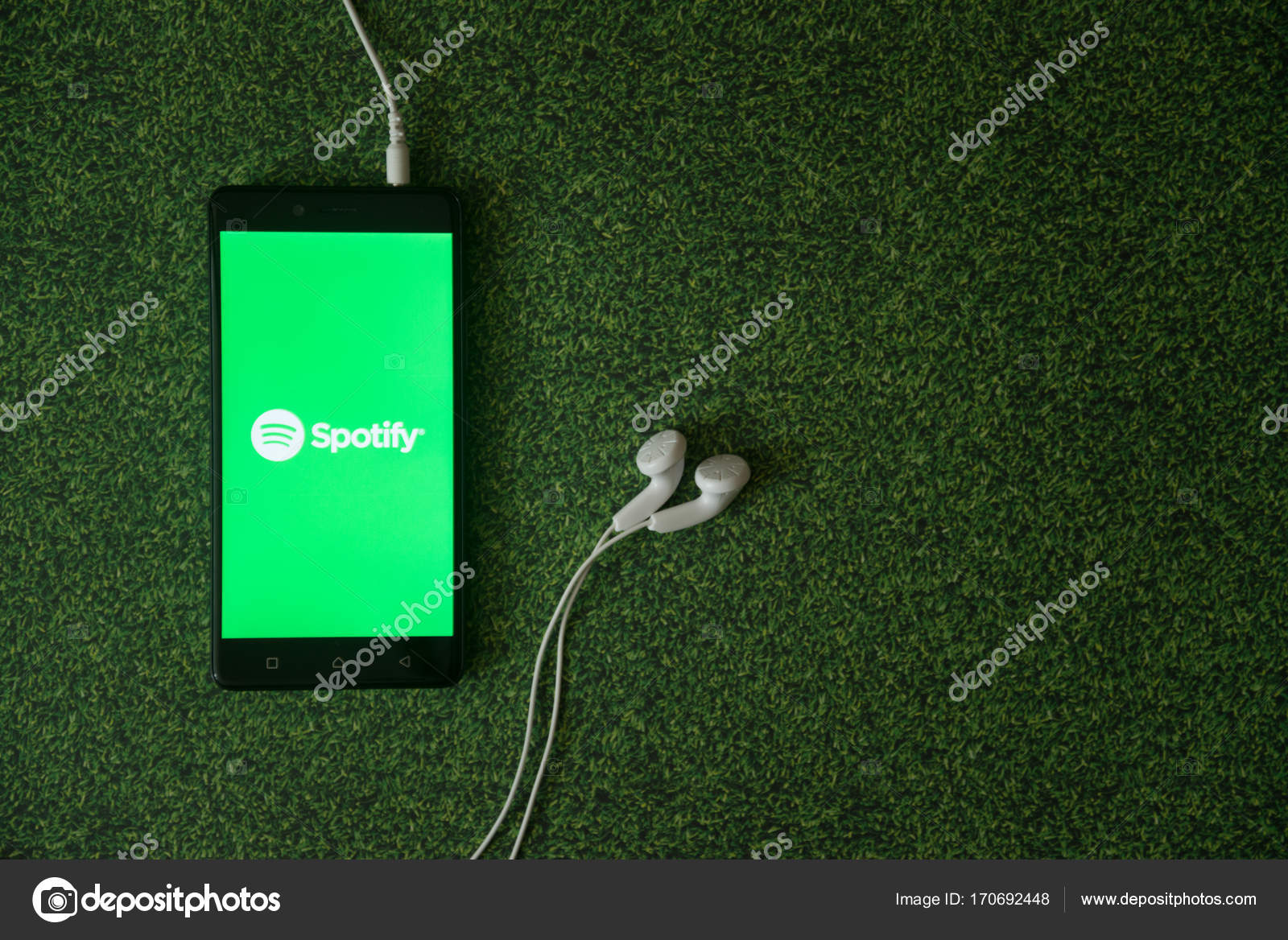 Spotify logo on smartphone screen on green grass background. – Stock ...