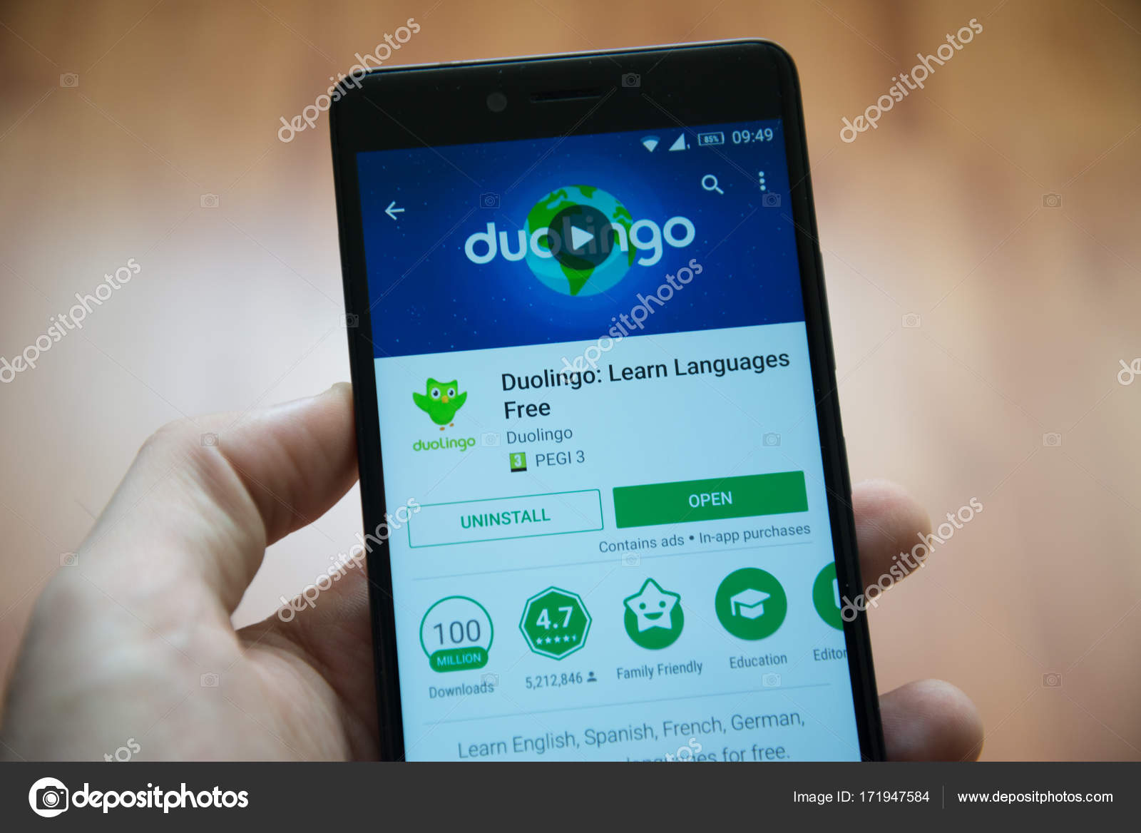 Man hand holding smartphone with Duolingo application in google play ...