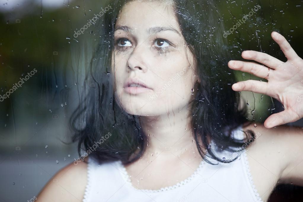 Sad Woman Looking Through Window — Stock Photo © RadaRani #128538848