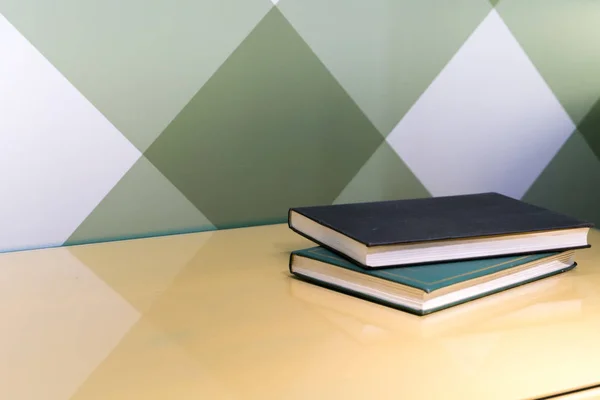 two diary books on the table near graphic wall - Stock Image - Everypixel