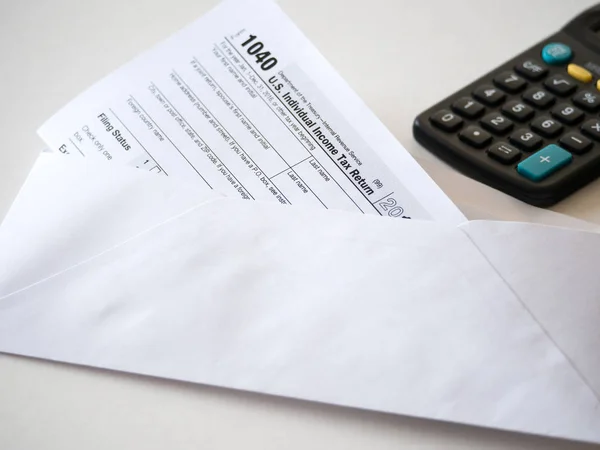 Closeup image of a stuffed envelope with the federal 1040 individual ...