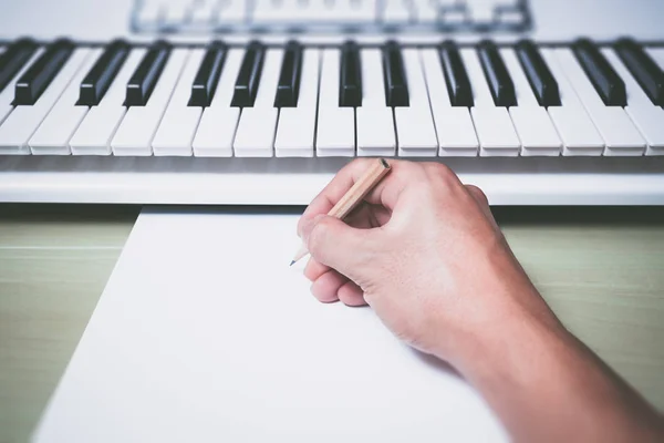 professional composer hands writing songs on blank white paper with ...