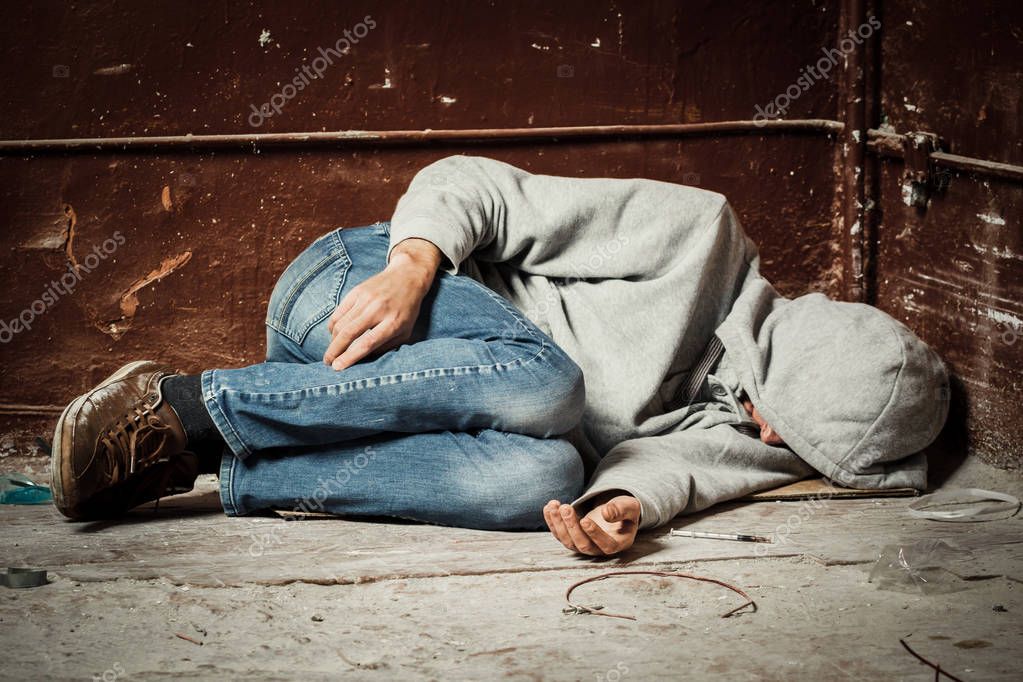 Un hombre es un drogadicto con una jeringa que usa drogas tiradas en el ...