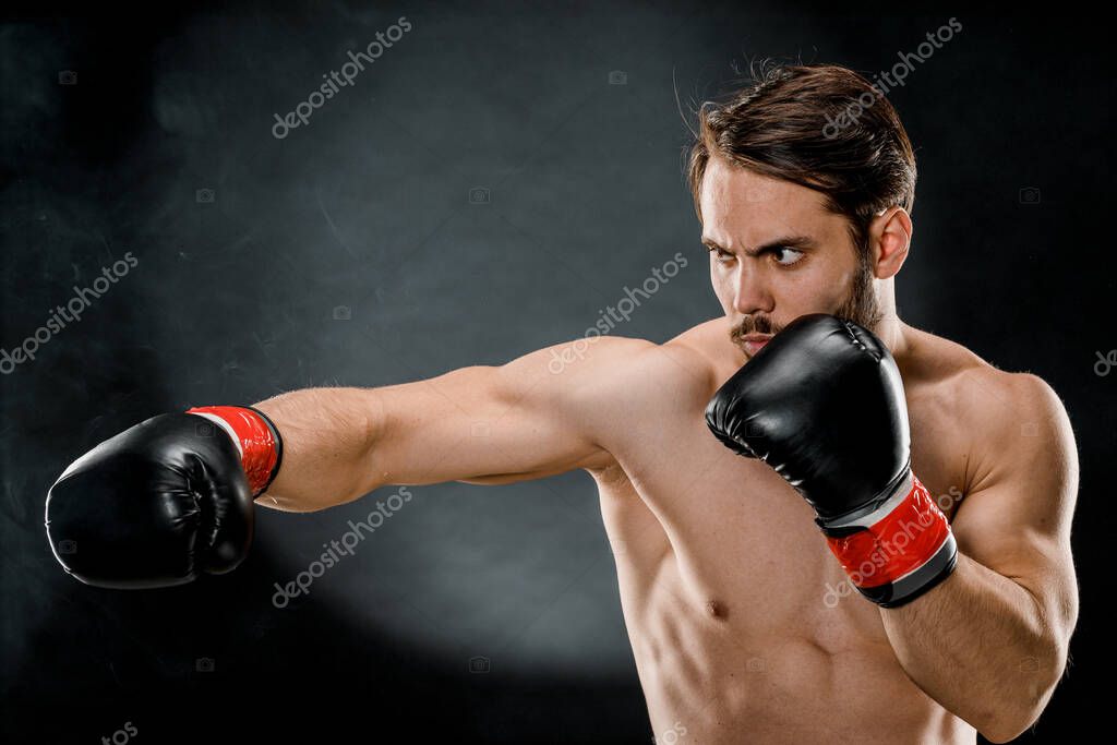 Un hombre con guantes de boxeo. Un hombre boxeando sobre un fondo negro ...