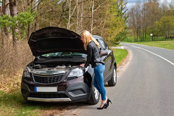 Young attractive desperate and confused woman stranded on roadside ...