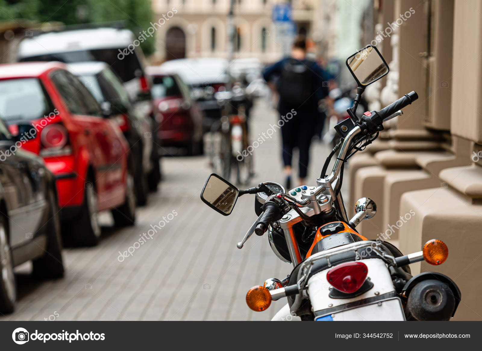 Rear view of powerful motorcycle parked on a sidewalk, defocused street ...