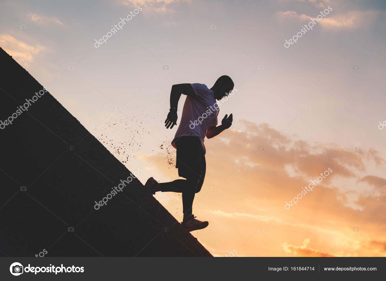 Strong man runs down a steep hill. The athlete is engaged in fitness in ...