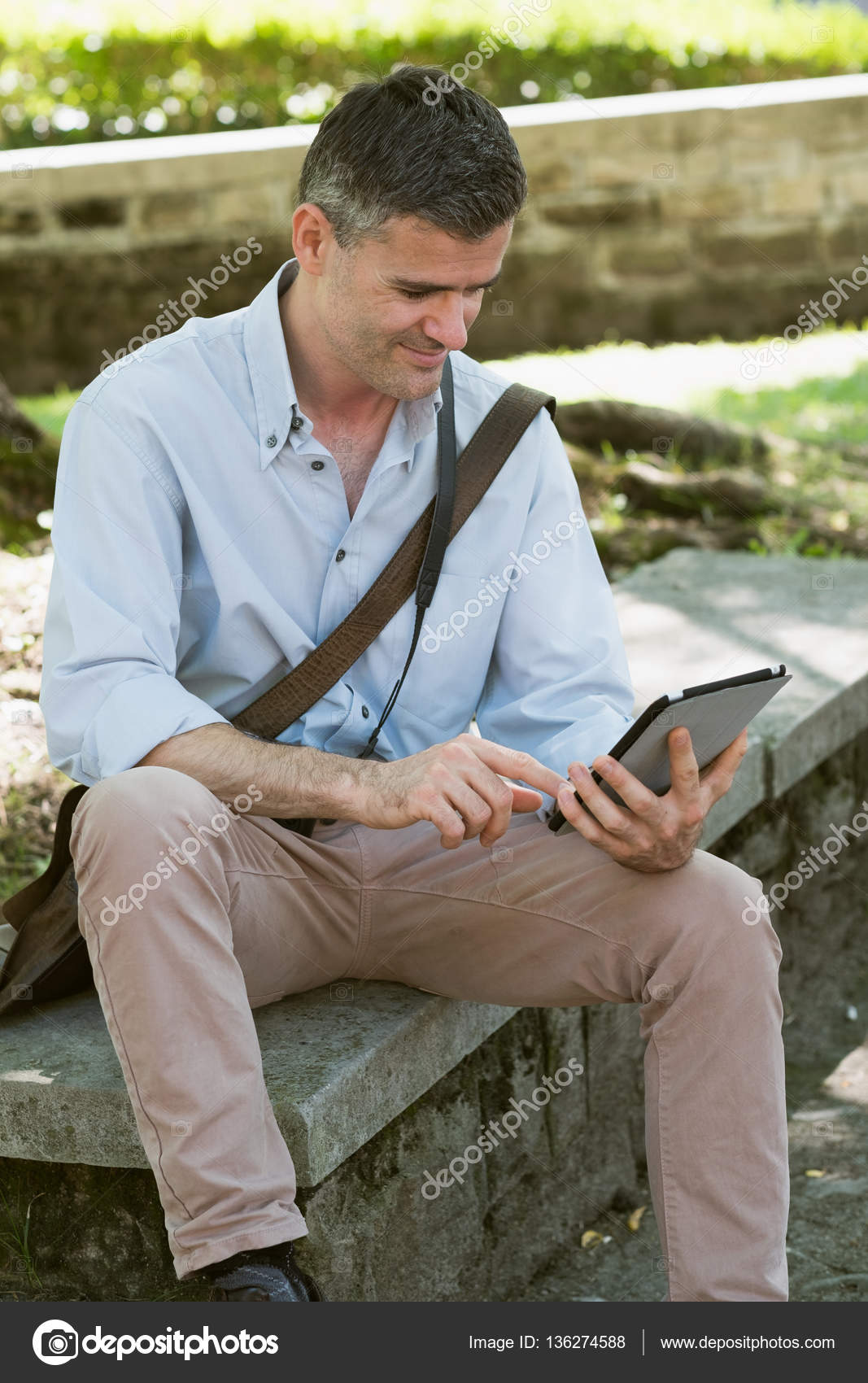 Man at park using tablet Stock Photo by ©stokkete 136274588