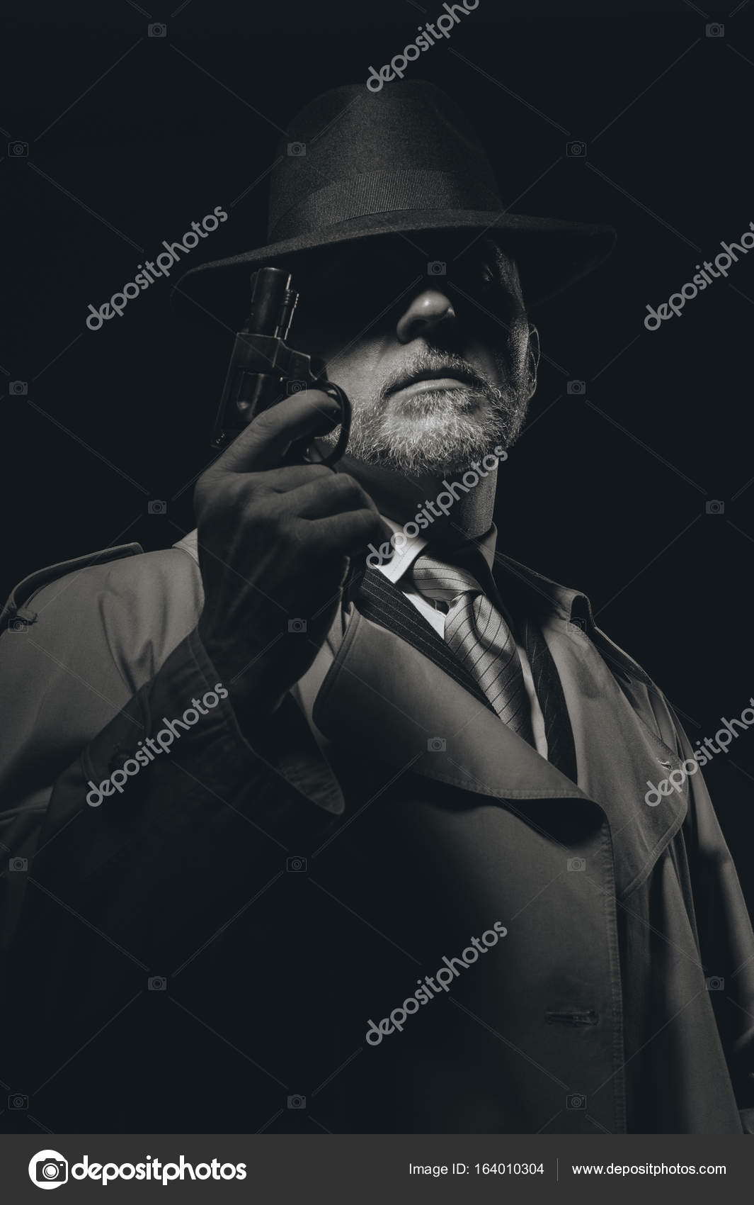 Detective holding gun in dark Stock Photo by ©stokkete 164010304
