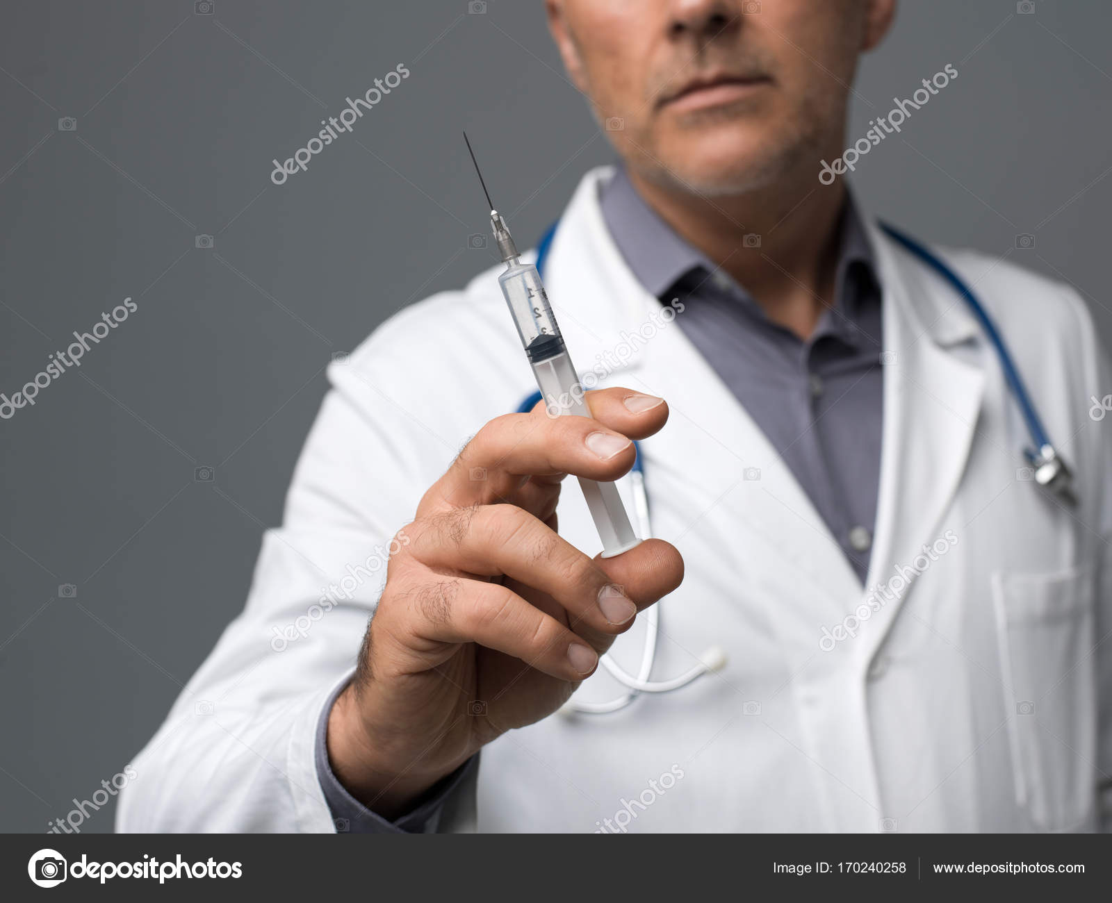 Doctor holding syringe Stock Photo by ©stokkete 170240258