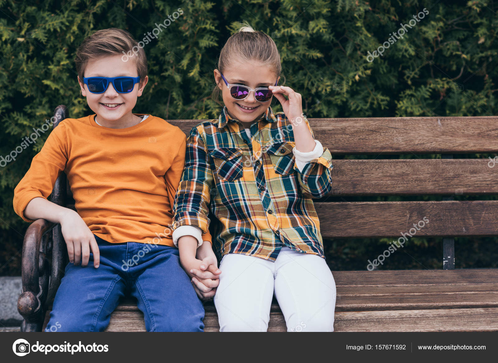 Adorable kids sitting on bench at park — Stock Photo © alebloshka ...