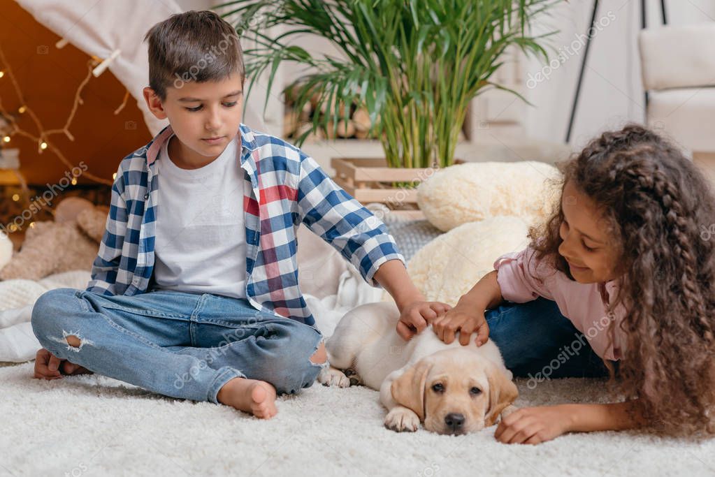 niños multiculturales con cachorro labrador 2024