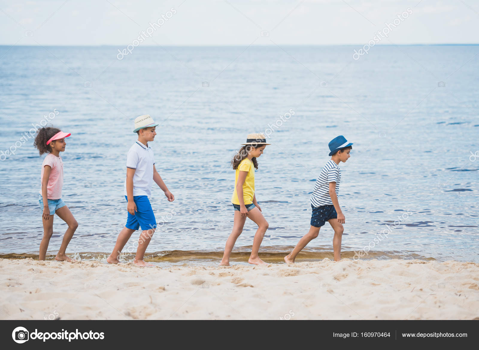 Multicultural kids walking on beach Stock Photo by ©alebloshka 160970464