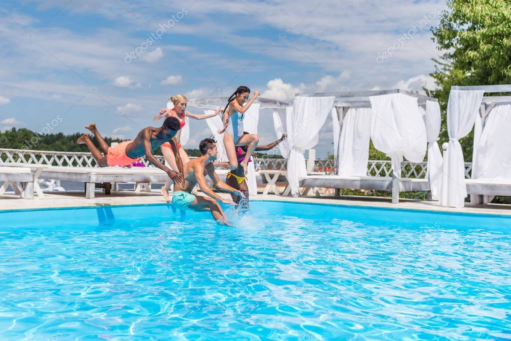 Multiethnic people jumping into swimming pool — Stock Photo ...