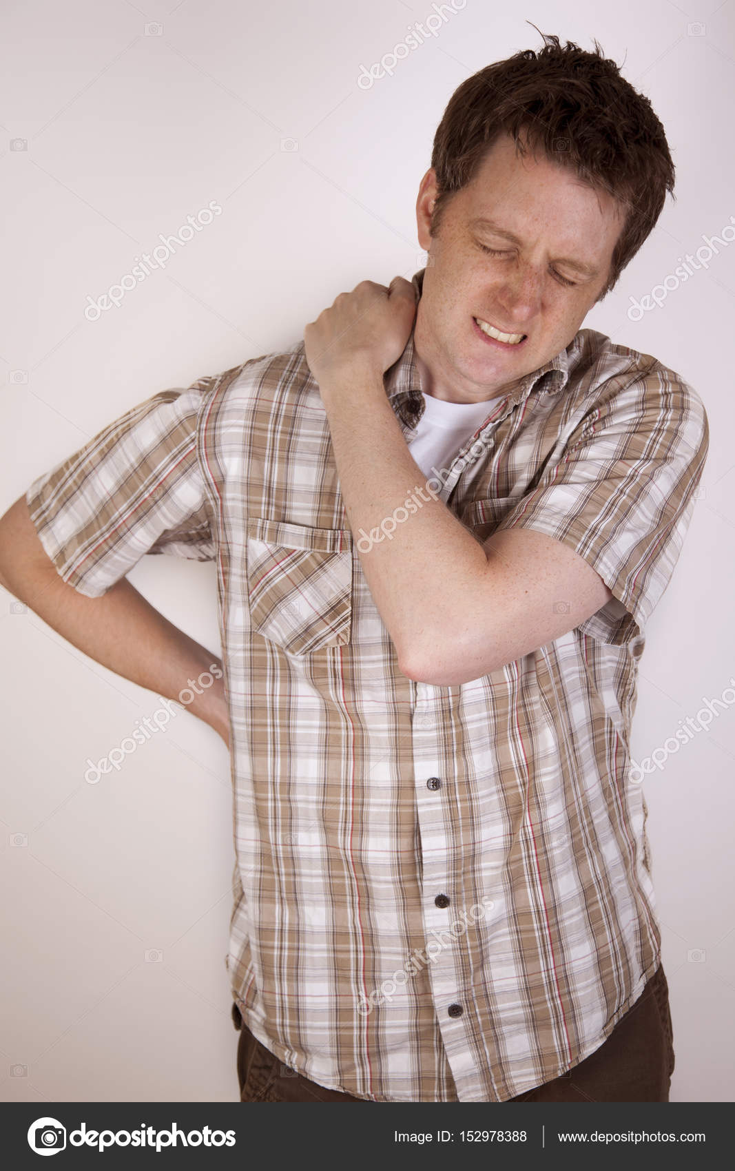 Man cringing from shoulder pain — Stock Photo © rustycanuck #152978388