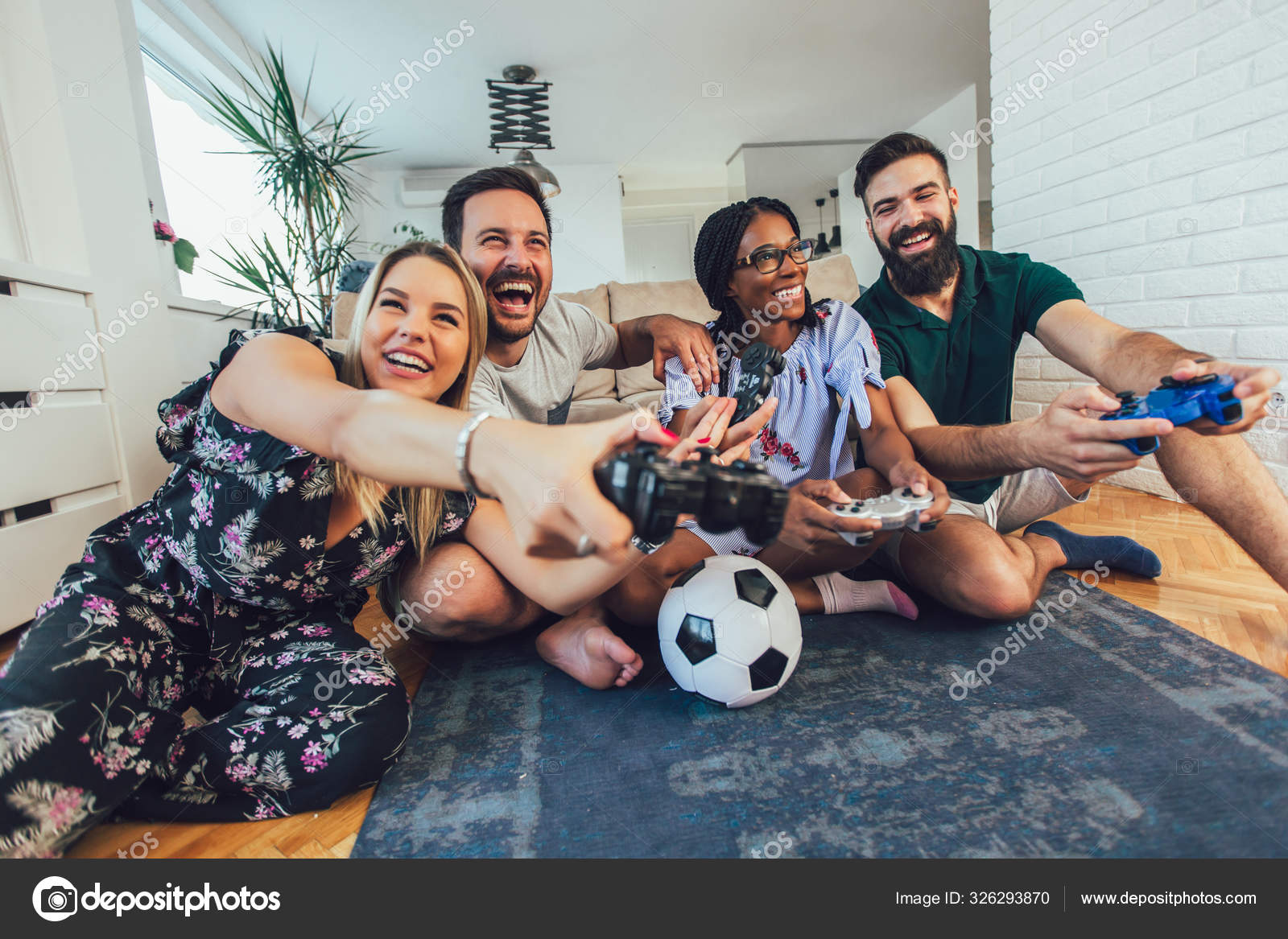 Happy multiethnic friends playing video game and having fun at h ...