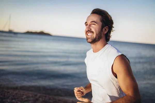 Running man jogging on beach. Male runner training outside worki Stock ...
