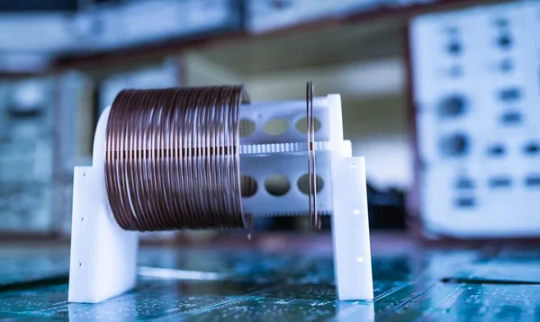 Close-up large and small coils with copper wire stand on a green ...