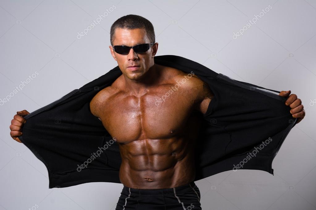 Muscular man opening jacket Stock Photo by ©kanzefar 127823638