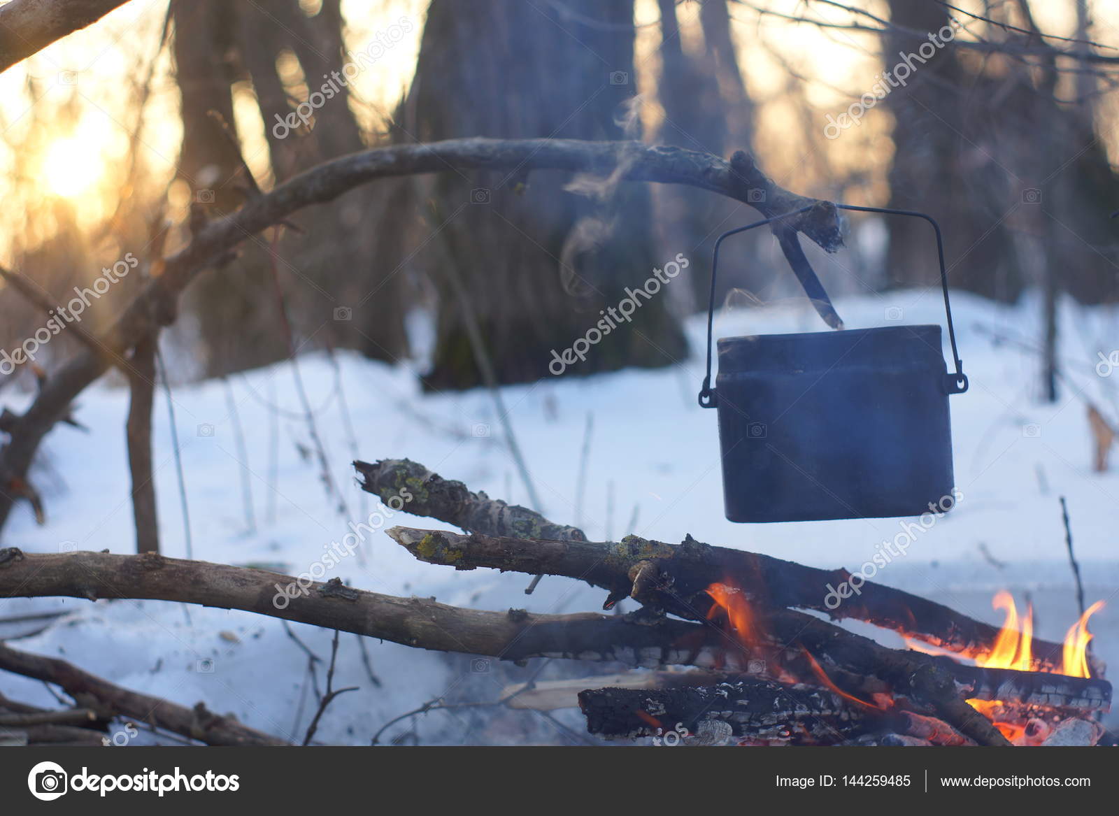 A pot of boiling water on the fire warms in the winter forest, — Stock ...