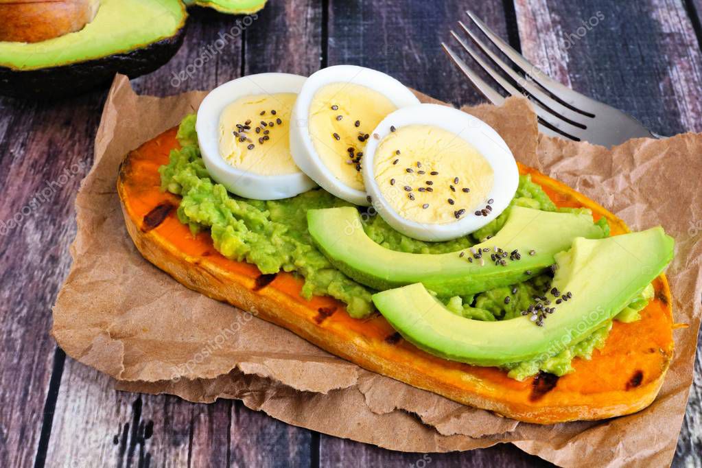 Tostadas de batata con aguacate, huevos y semillas de chía. Escena de ...