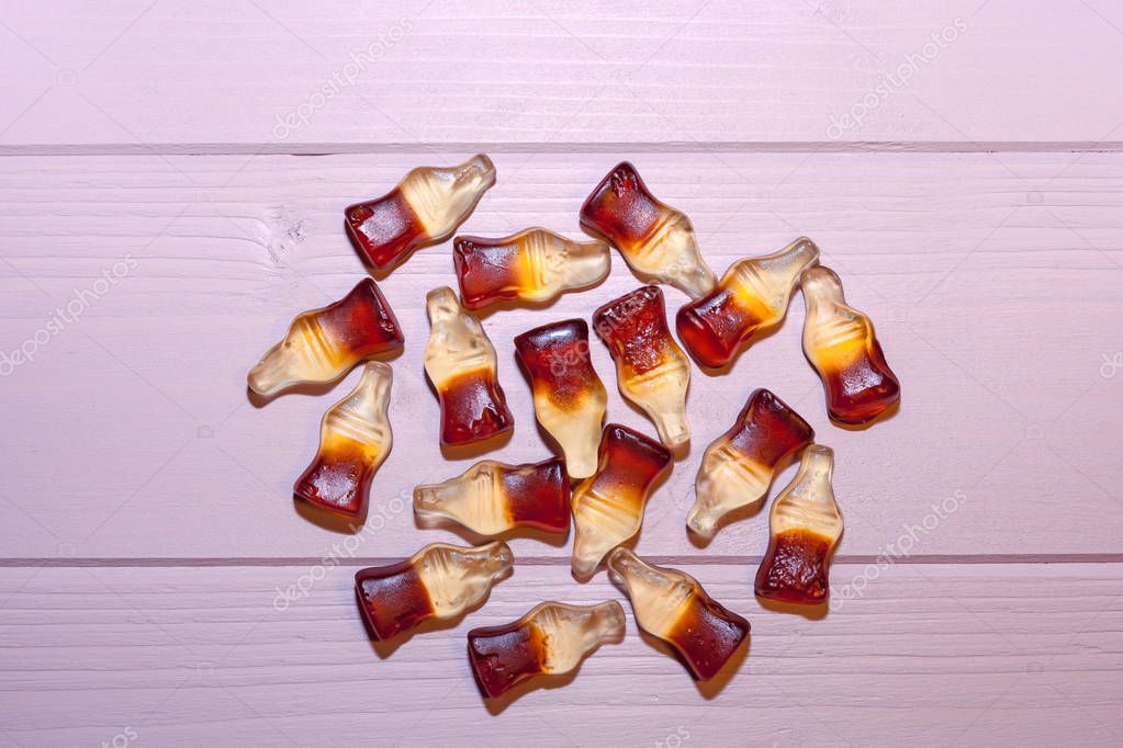 Botellas de cola de caramelo sobre fondo de madera rosa apagada ...