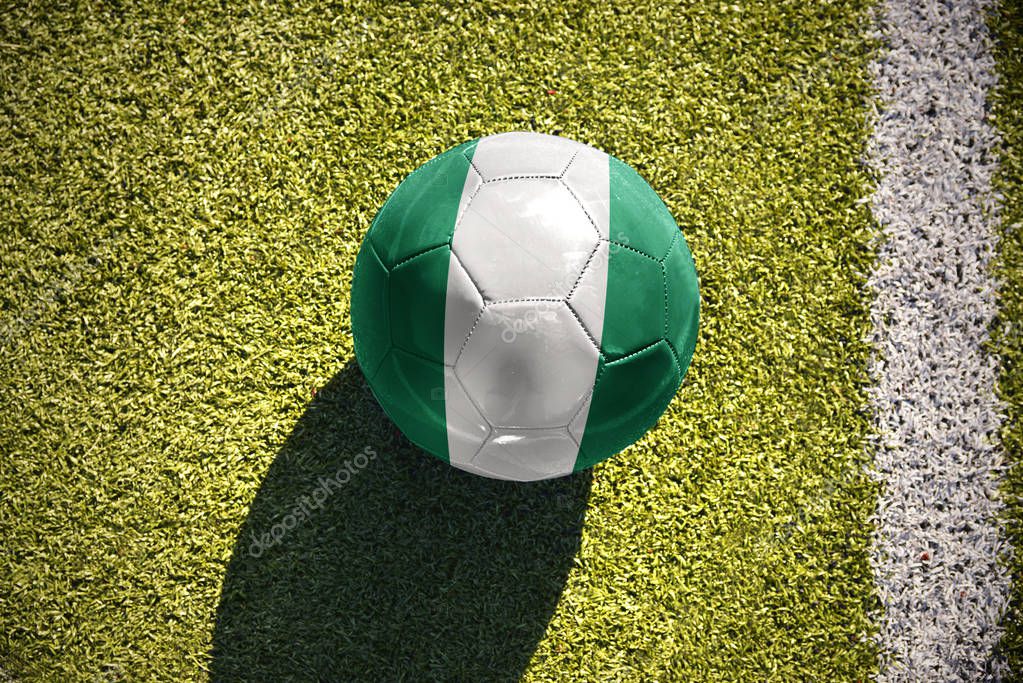 pelota de f tbol con la bandera nacional de nigeria se encuentra en el campo 2024
