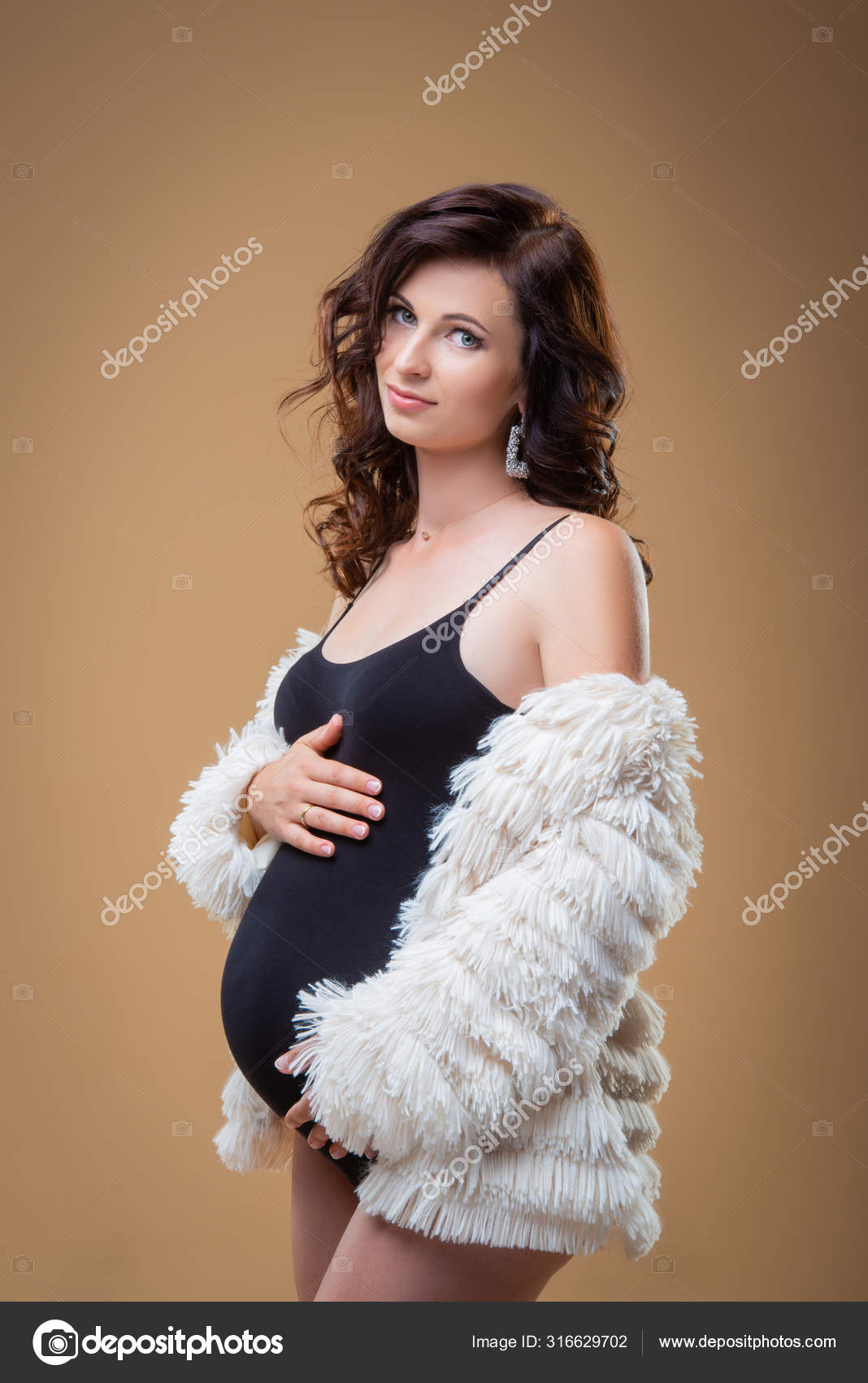 Młoda brunetka ciężarna kobieta w futrze na równym tle. Piękna stylowa zdrowa ciąża. Ubrania ...