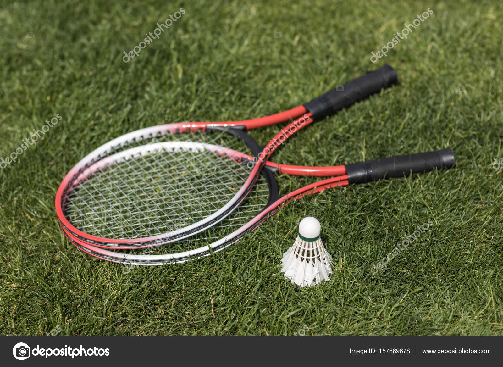 Badminton rackets with shuttlecock on grass — Stock Photo ...