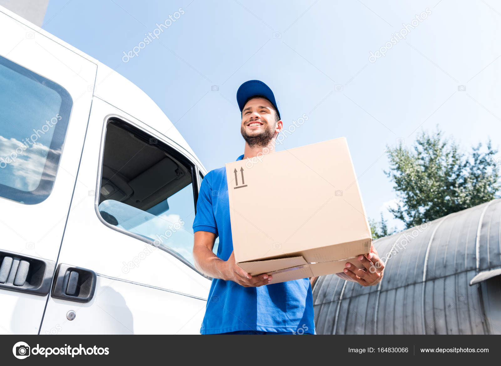 Delivery man with cardboard box — Stock Photo © IgorVetushko #164830066