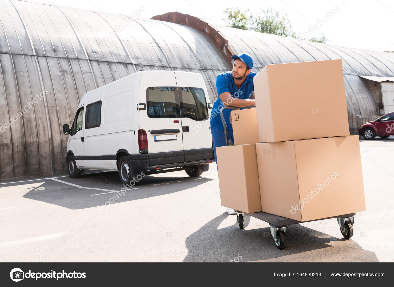 Delivery man with boxes on cart — Stock Photo © IgorVetushko #164830218
