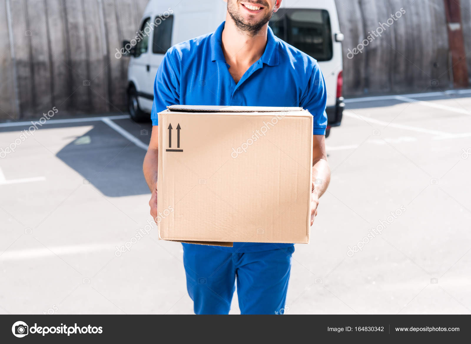 Delivery man with cardboard box — Stock Photo © IgorVetushko #164830342