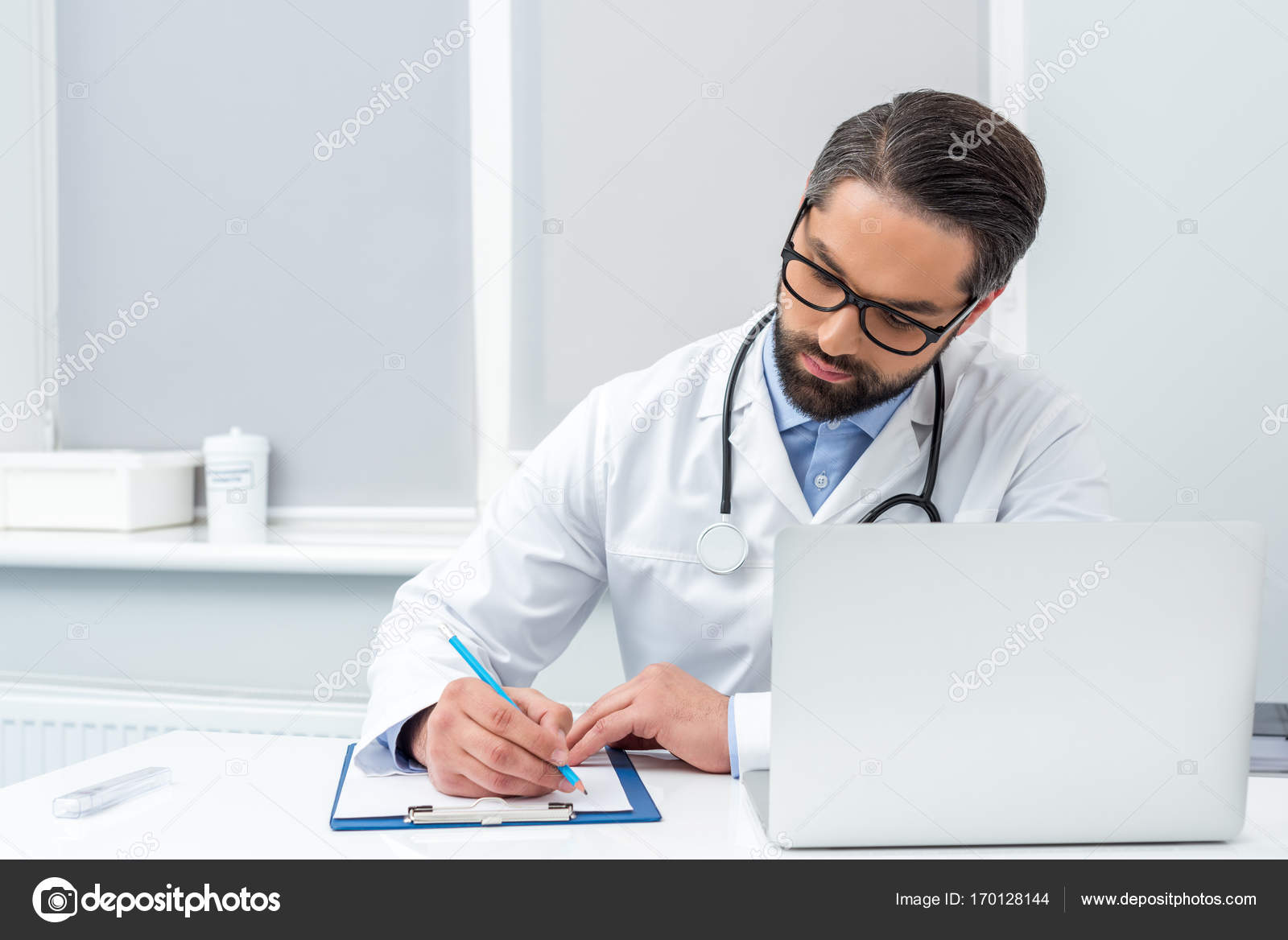 Doctor writing in clipboard — Stock Photo © IgorVetushko #170128144