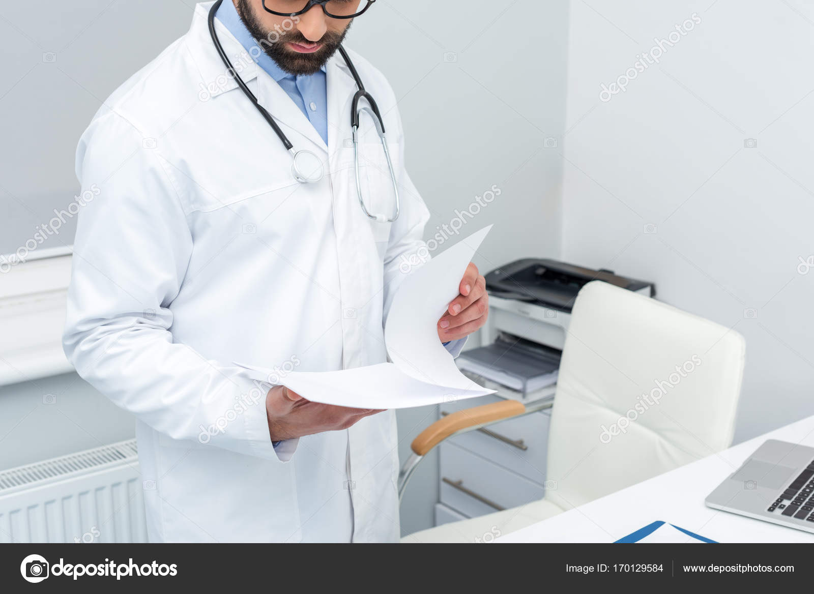 Doctor looking at papers — Stock Photo © IgorVetushko #170129584