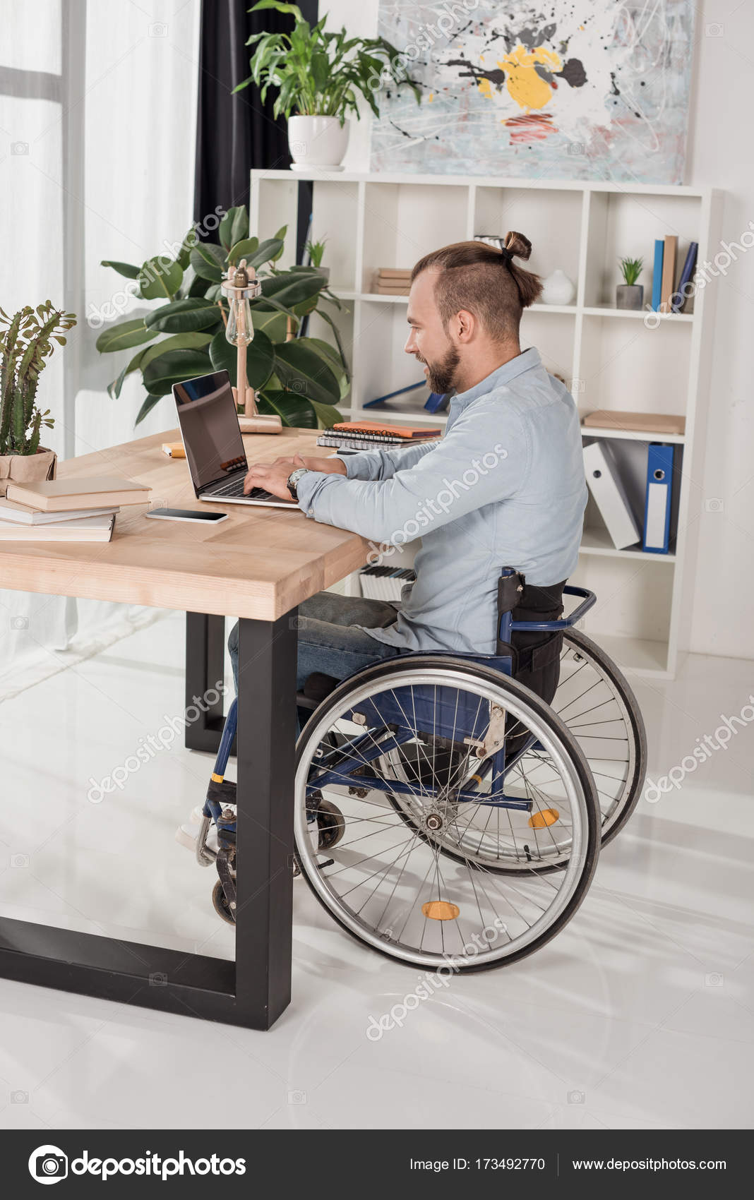 Disabled man using laptop — Stock Photo © IgorVetushko #173492770