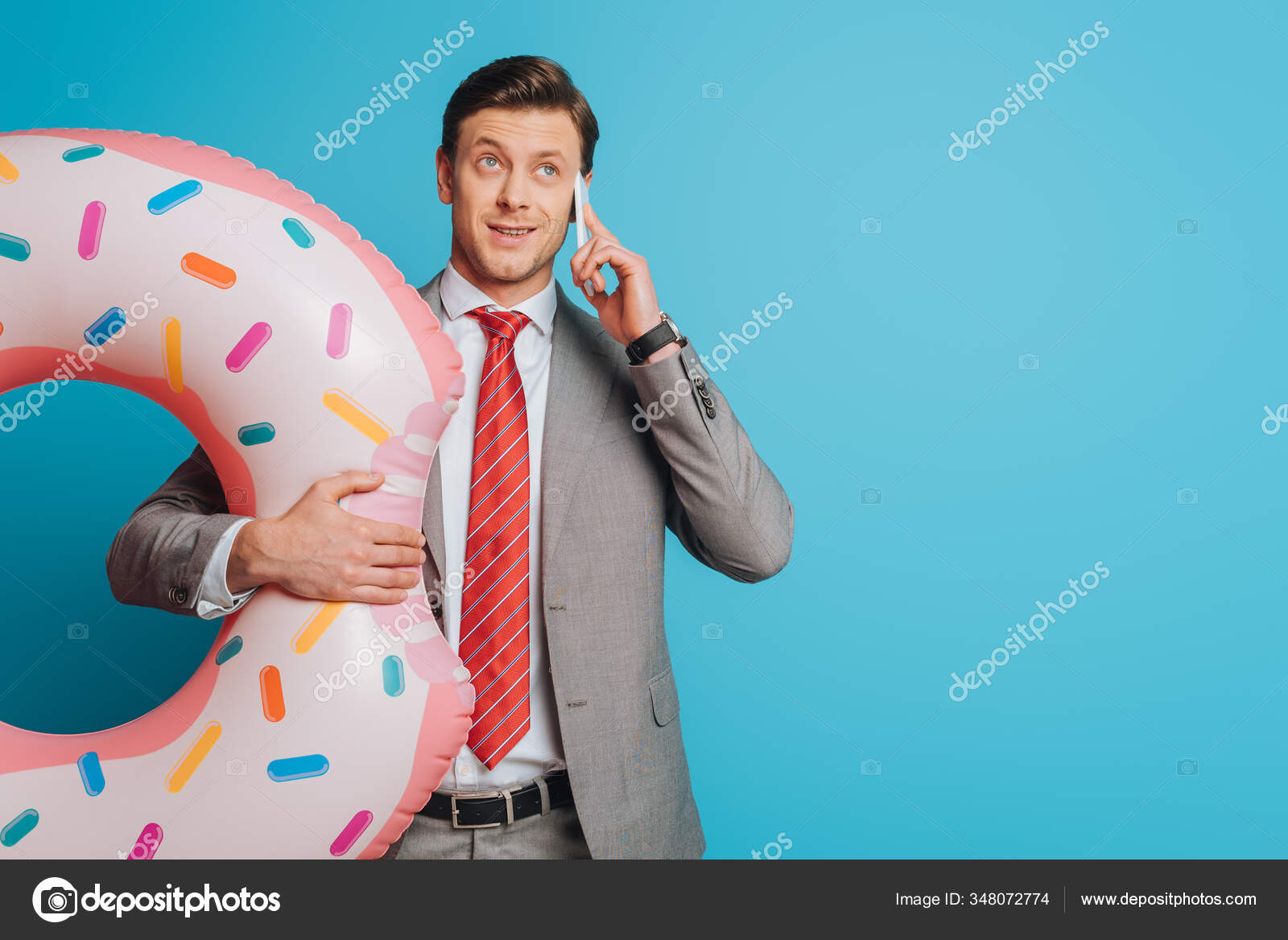 Happy Businessman Swim Ring Talking Smartphone While Looking Away Blue
