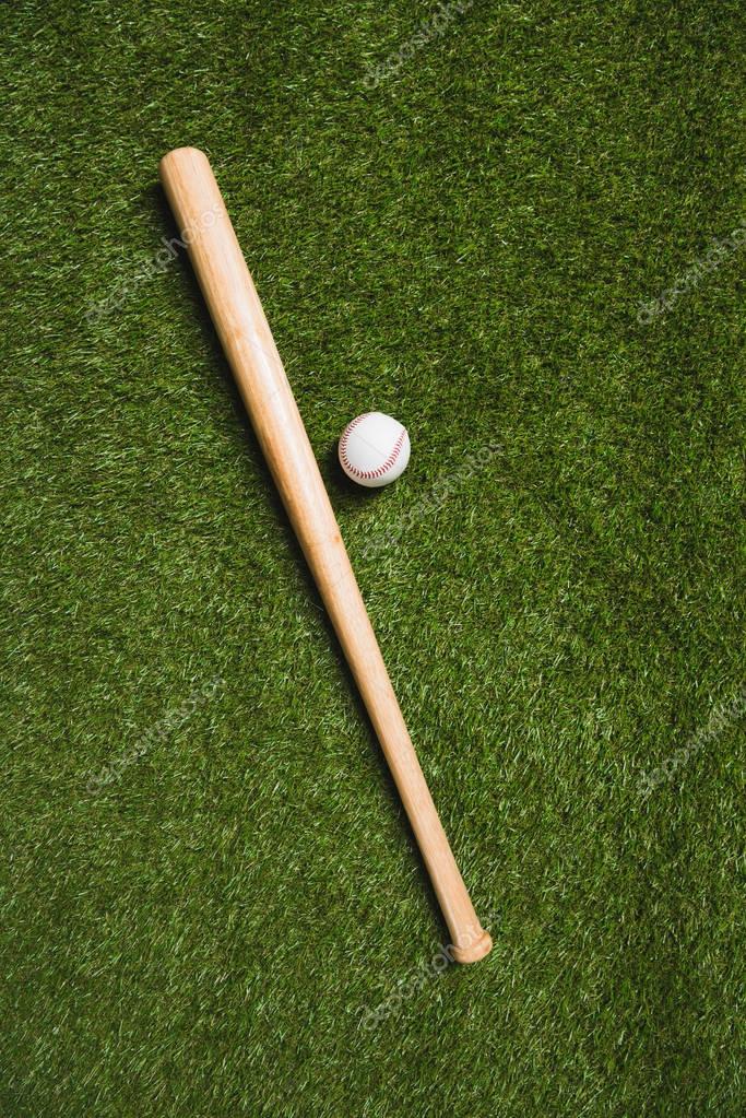Bate de béisbol y pelota sobre hierba 2024