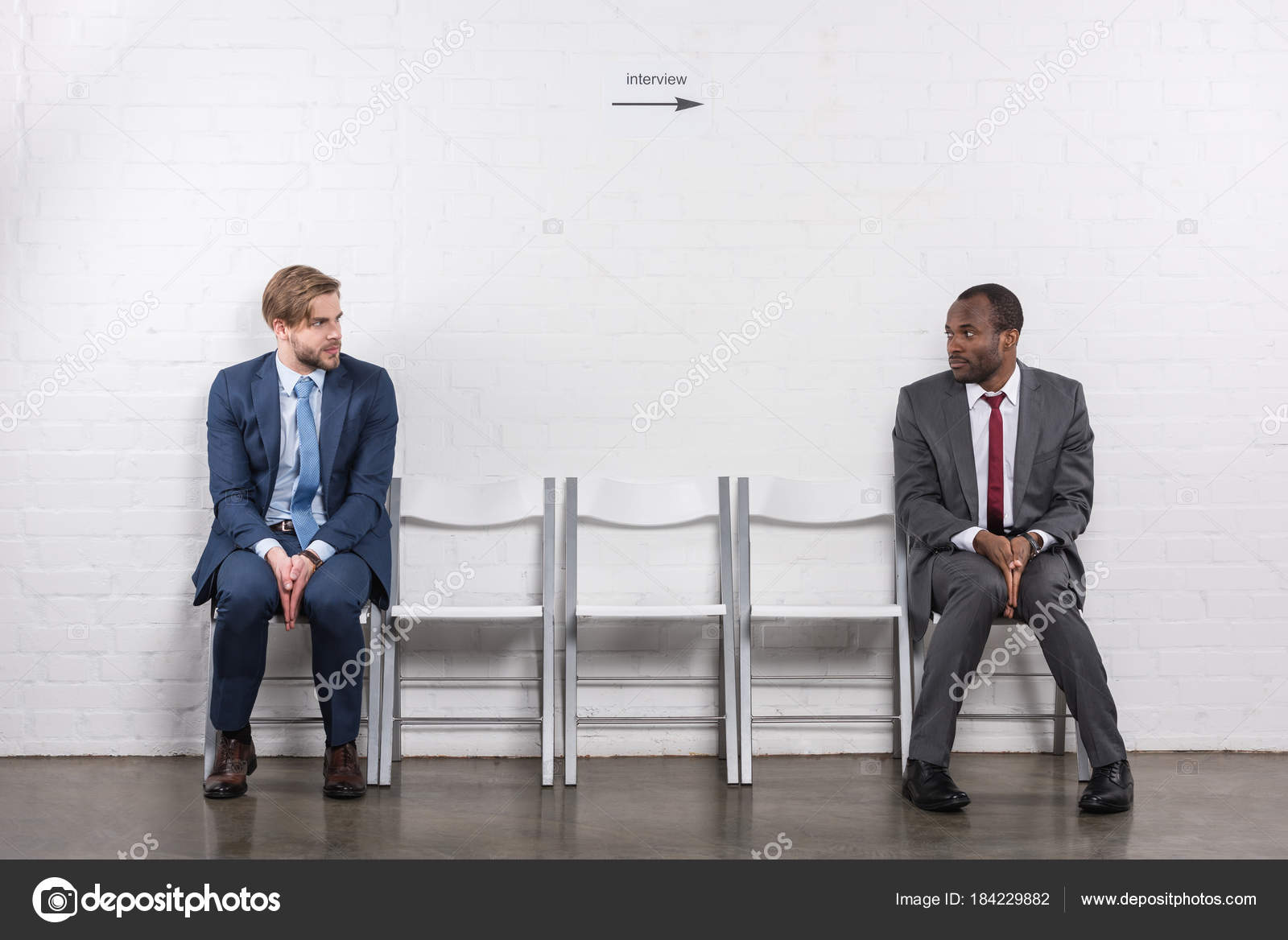 Scared Multiethnic Businessmen Looking Each Other While Waiting Job ...