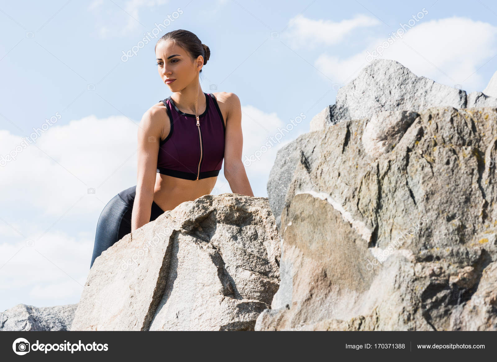 Sportswoman posing on rocks Stock Photo by ©EdZbarzhyvetsky 170371388