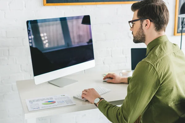 Young man looking at computer screen at home office - Stock Image ...