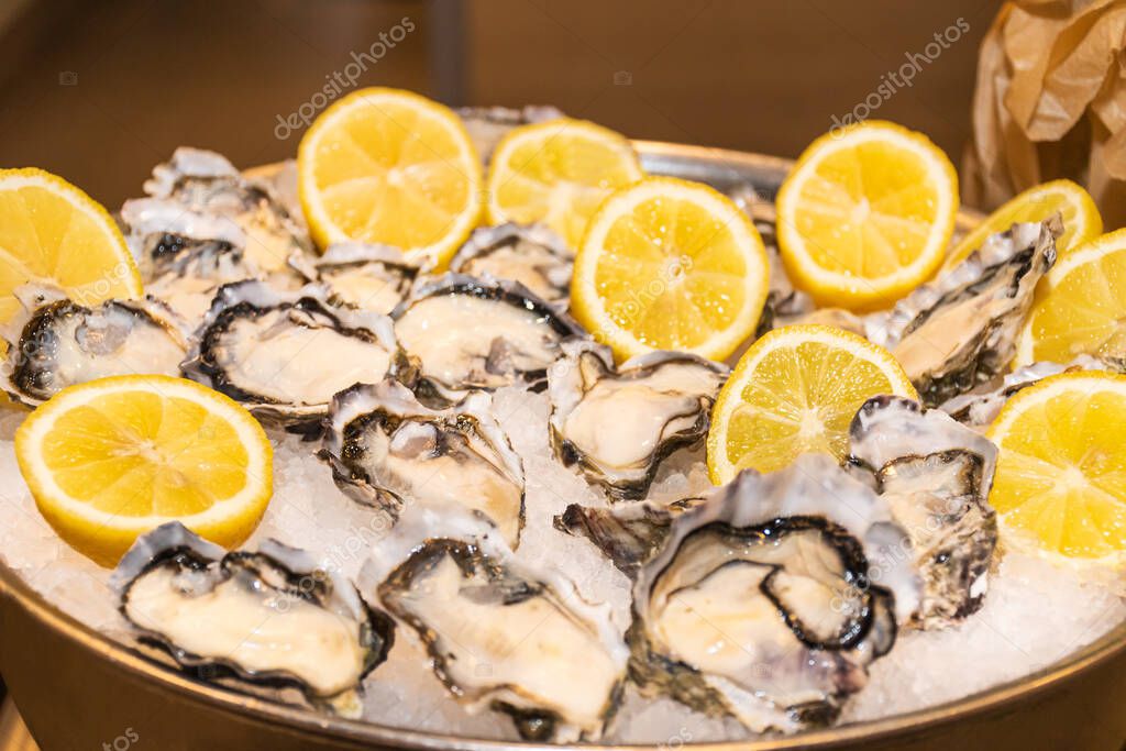 Fresh Fine de Claire Ostras servidas con rodajas de limón en hielo ...