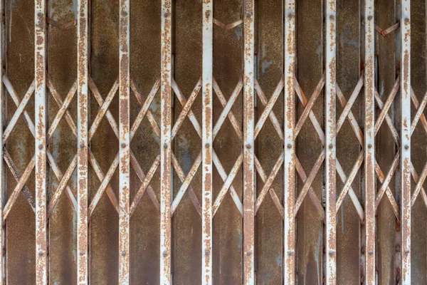 Close up old rusty metal fence gate. Old rusty steel metal sliding door ...