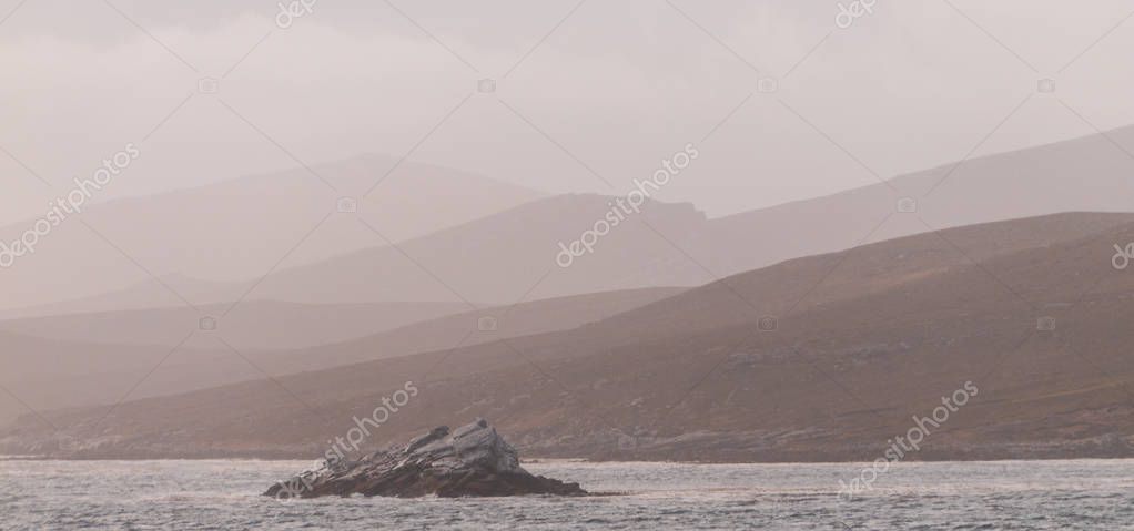 Varias capas de colinas rocosas marcan la costa de las islas Malvinas. 2022